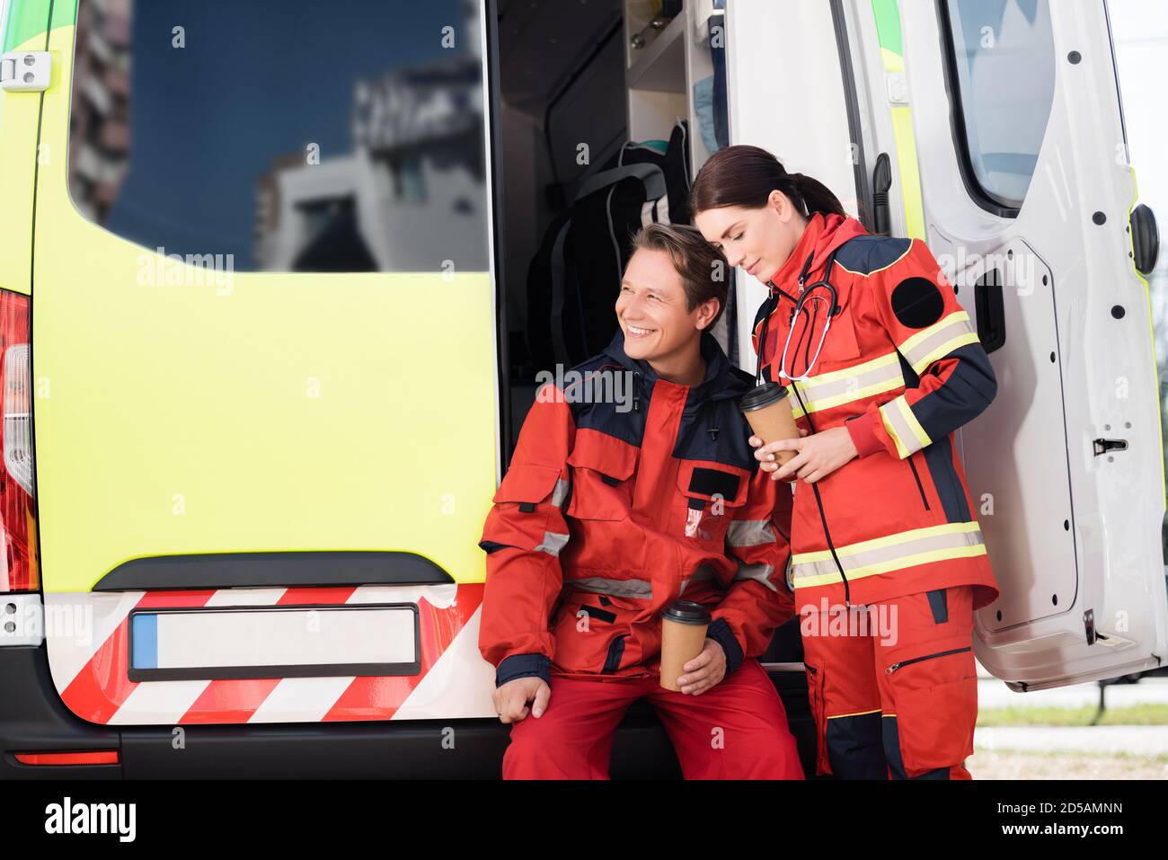 Paramedics in uniform holding coffee to go near ambulance car Stock ...