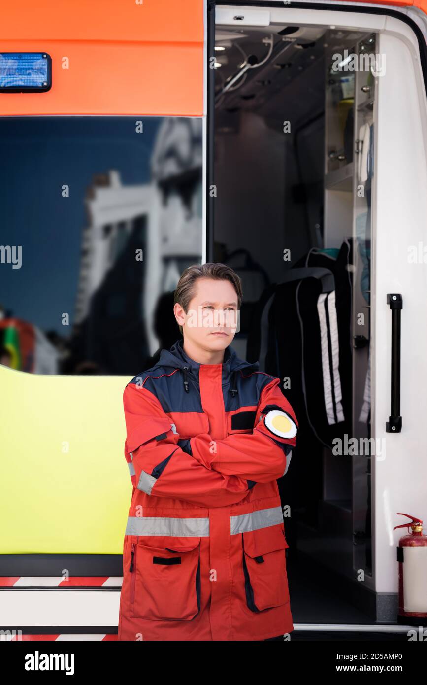 Paramedic with crossed arms standing near ambulance auto outdoors Stock ...