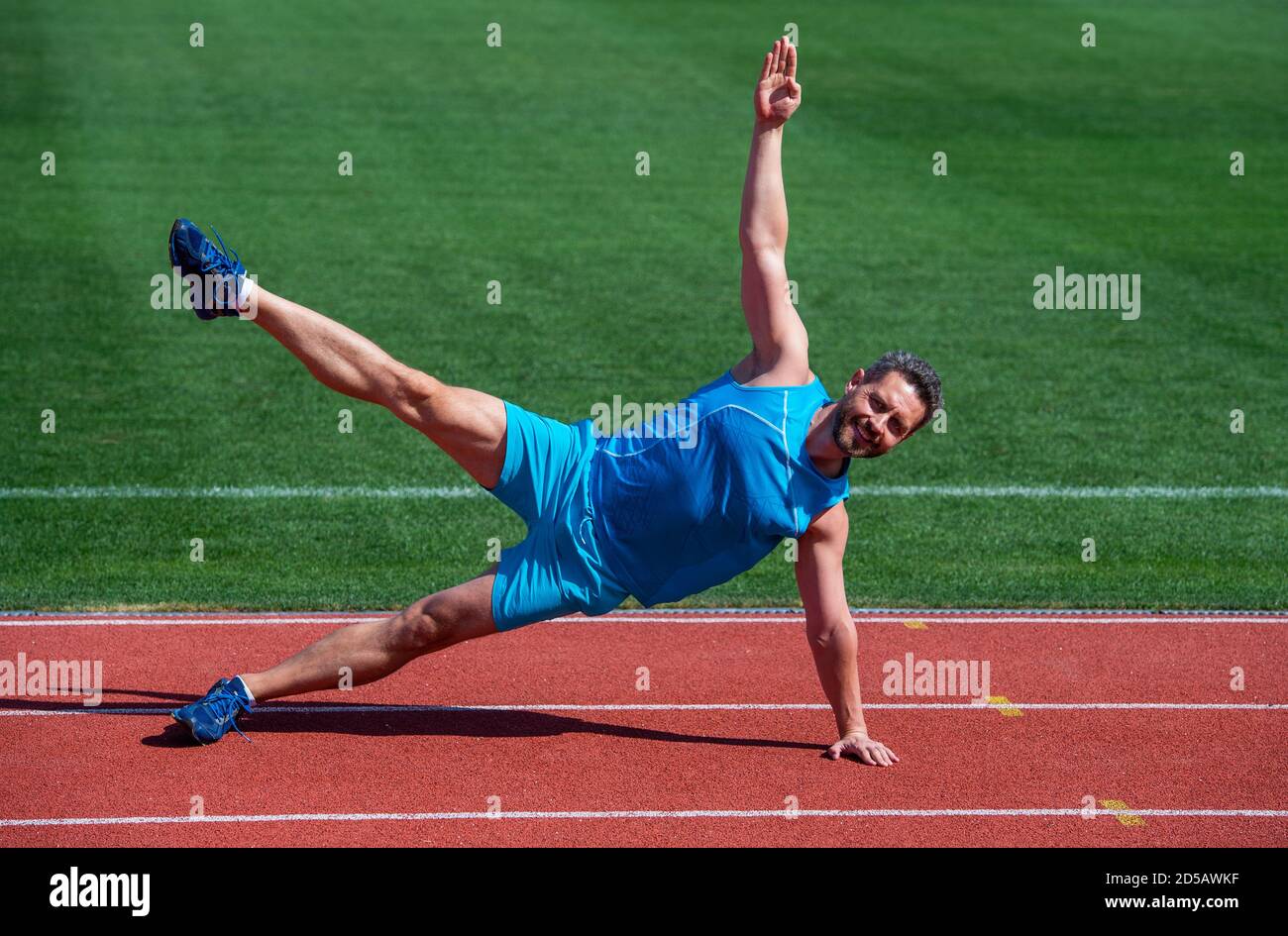 muscular man stand in side plank stretching on sport training, pilates ...
