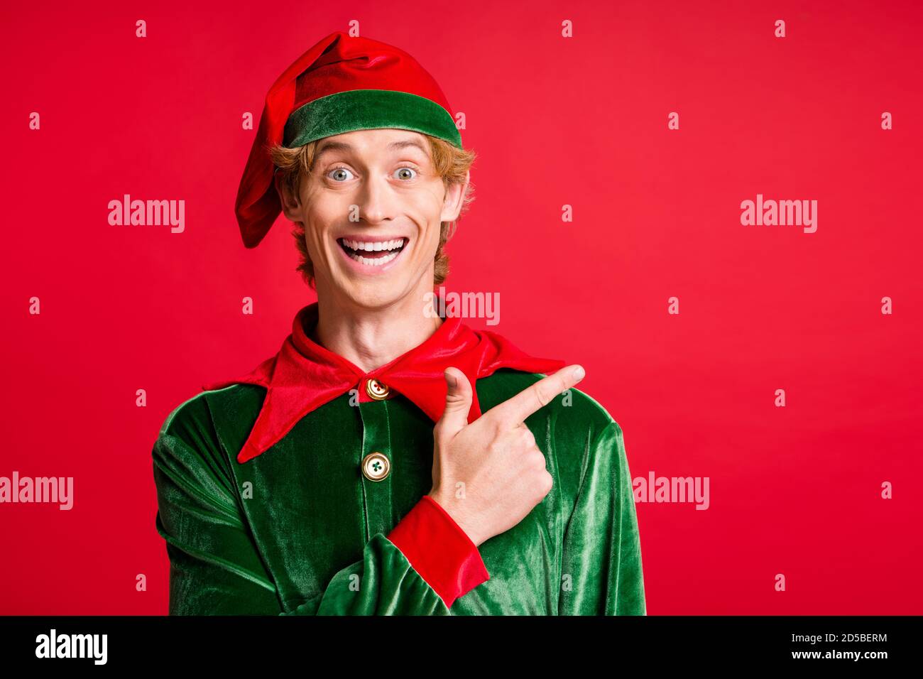 Portrait of crazy funny surprised elf guy point finger empty space at x ...