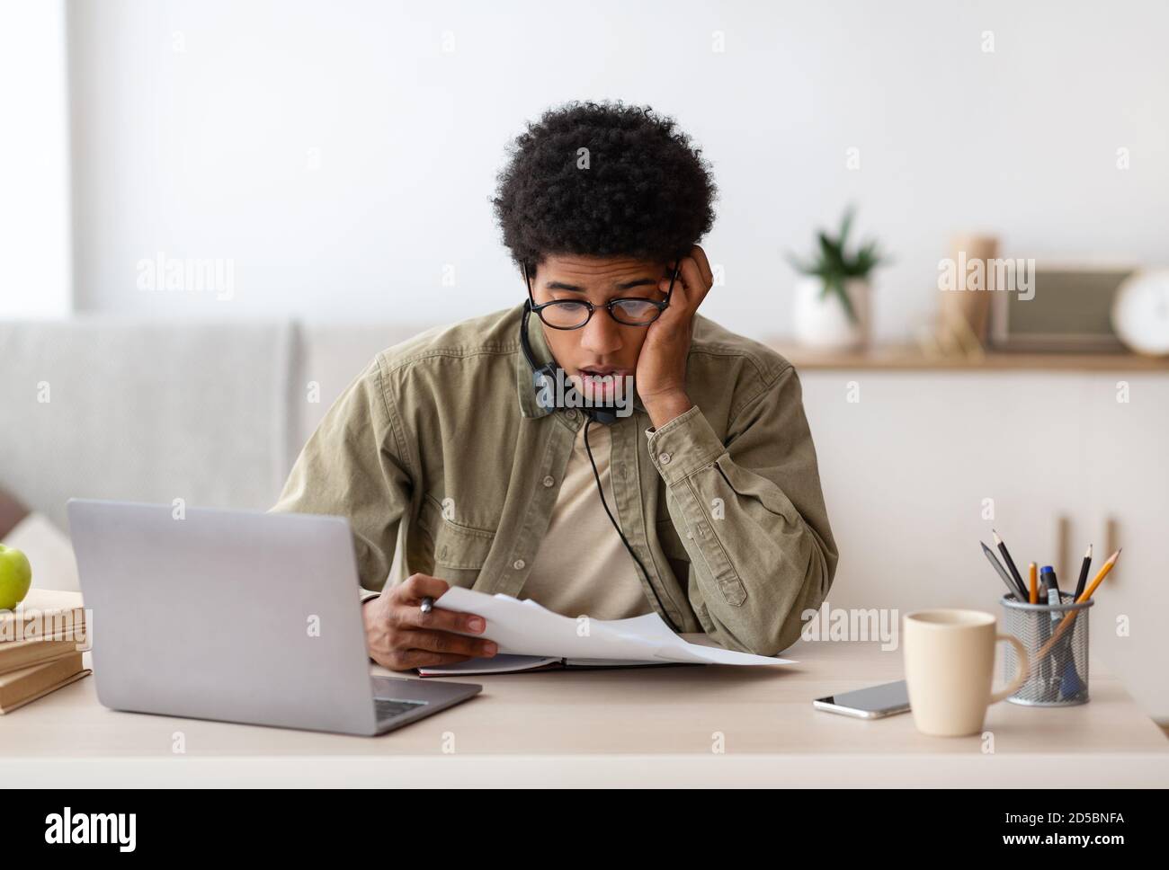 E-learning concept. Black teenage guy shocked over complicated test or ...