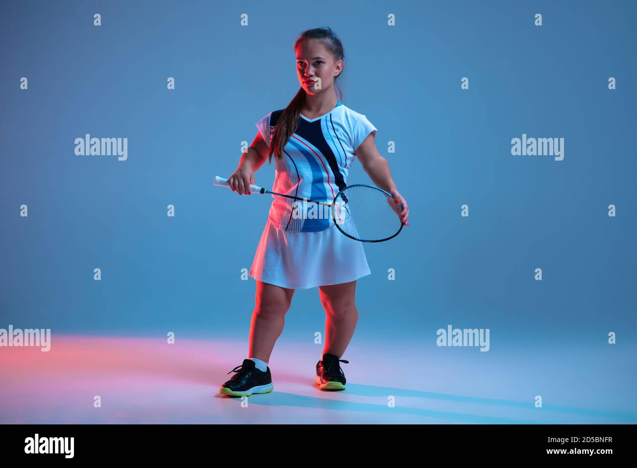 Leader. Beautiful dwarf woman practicing in badminton isolated on blue ...