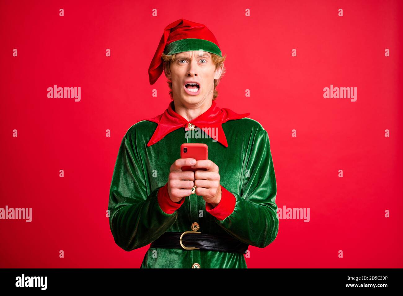 Frustrated elf guy hold smartphone with horrible x-mas social media ...
