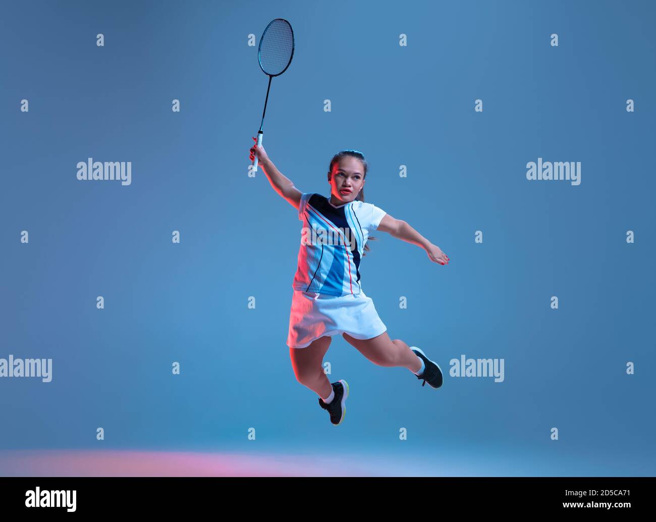 Strong. Beautiful dwarf woman practicing in badminton isolated on blue ...