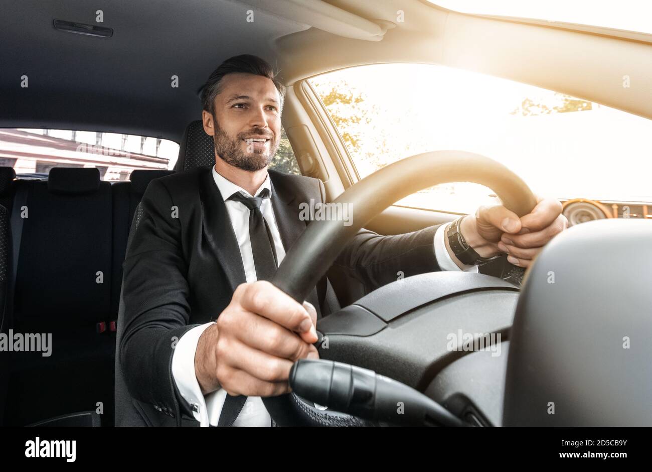 Happy rich businessman in suit driving car Stock Photo - Alamy