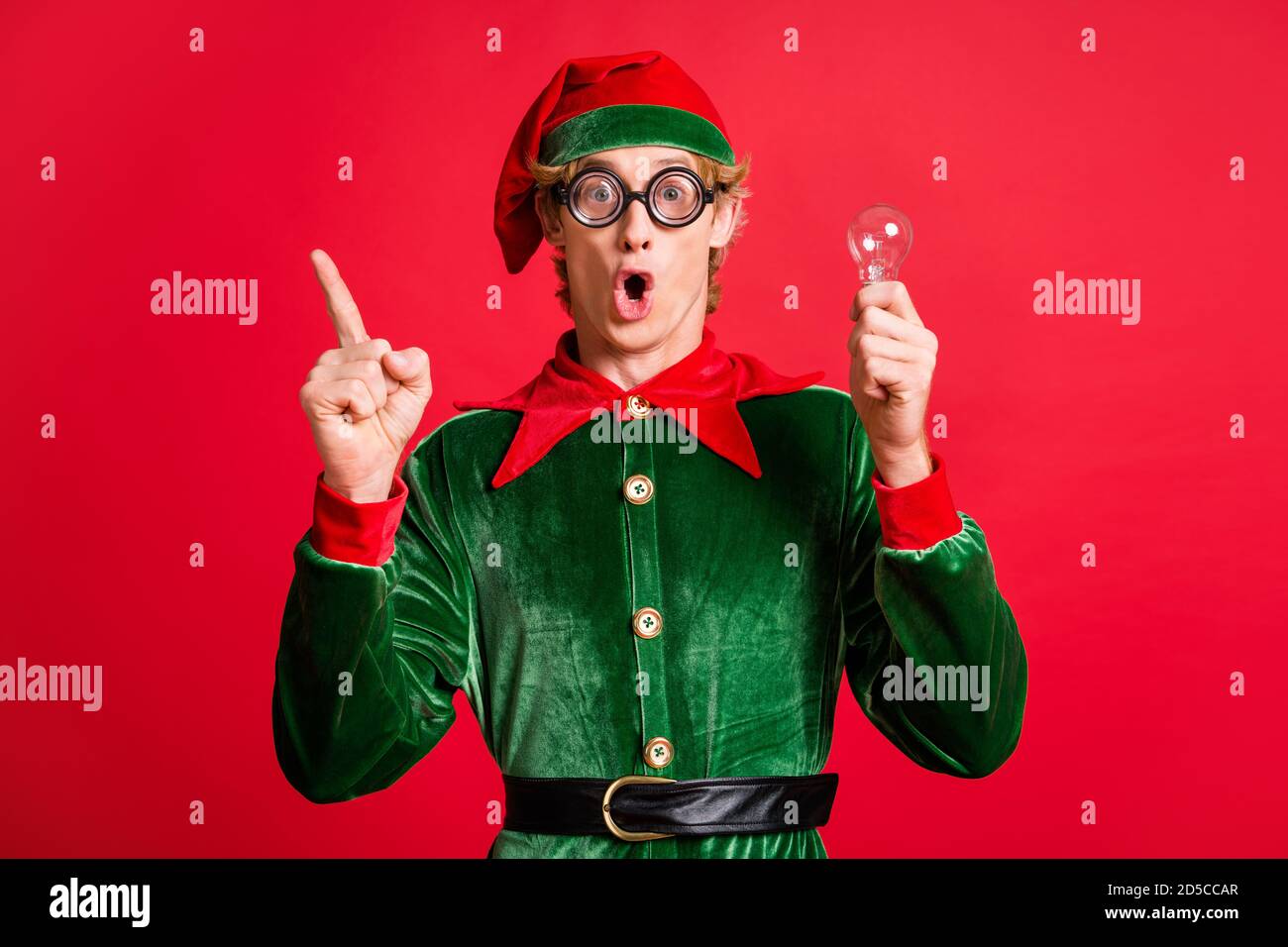 Astonished elf raise finger up hold light bulb clever think concept ...