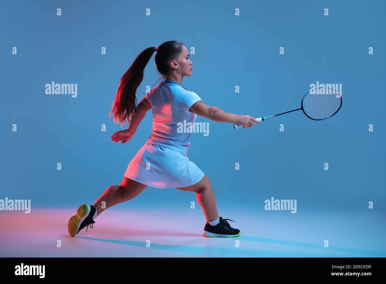 Winner. Beautiful dwarf woman practicing in badminton isolated on blue ...