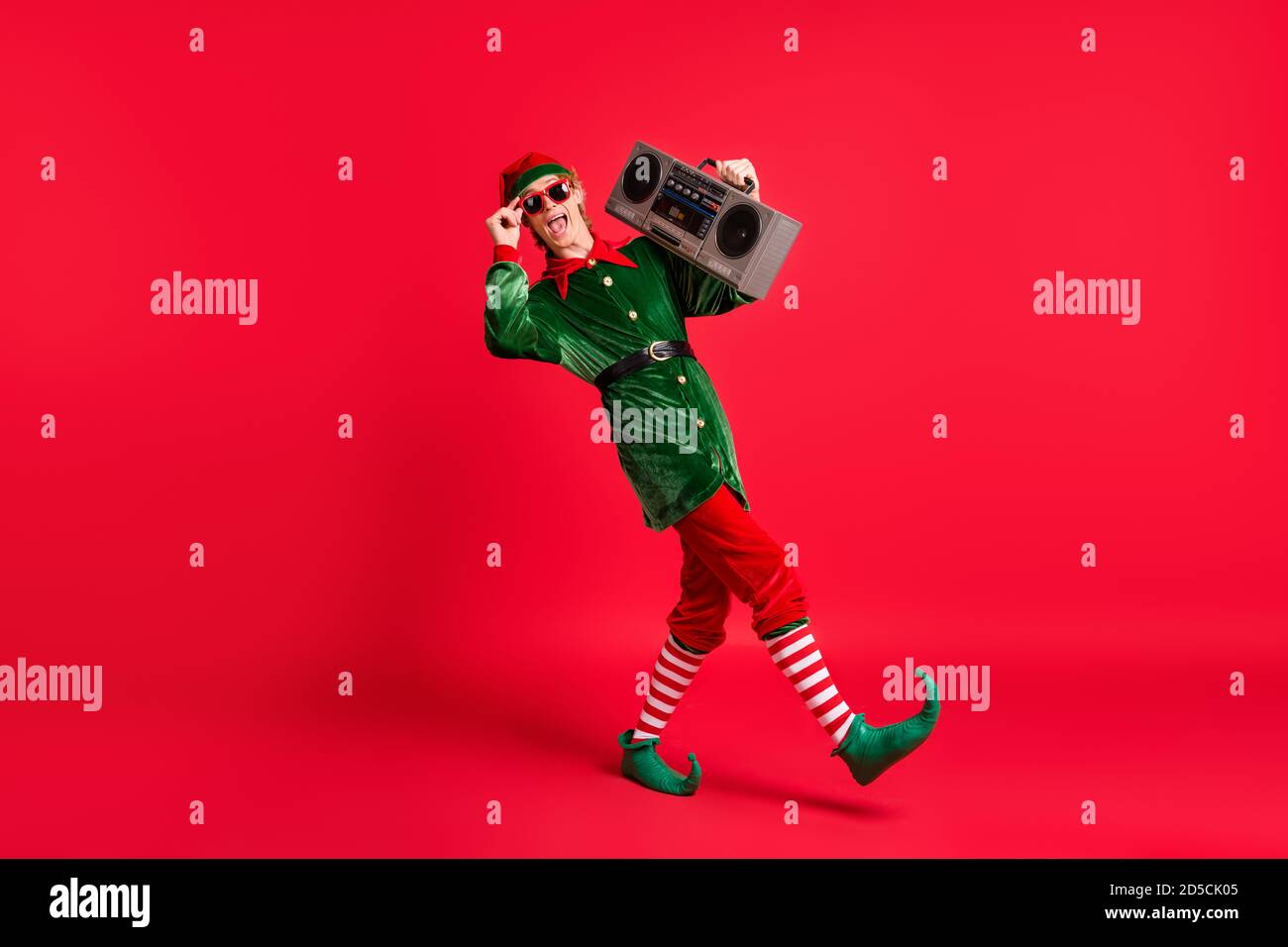 Full size profile side photo of crazy elf hold boom box go wear green ...