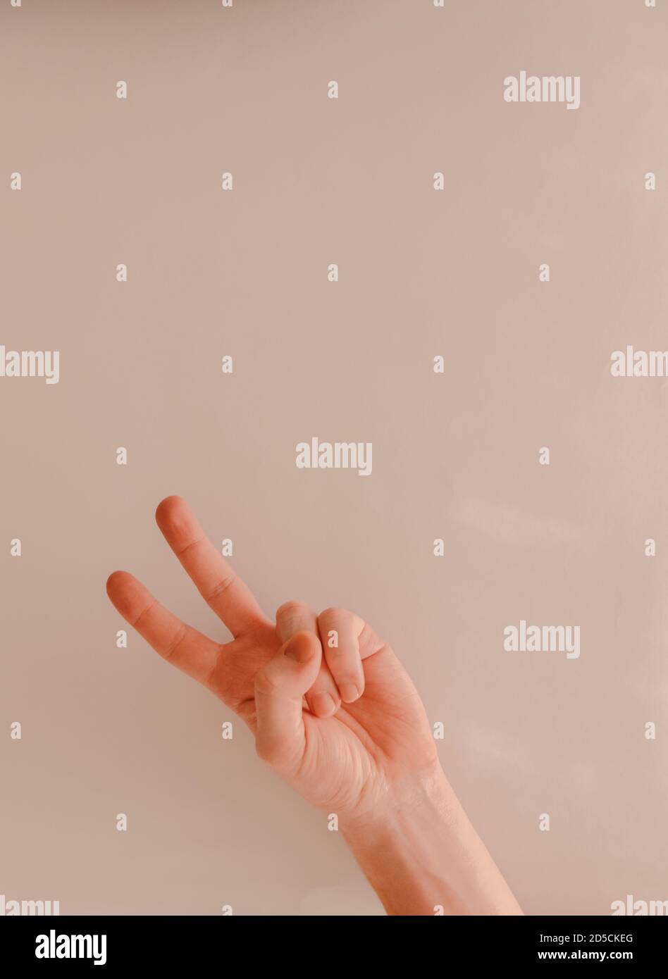 Vertical shot of a hand showing the peace sign Stock Photo - Alamy