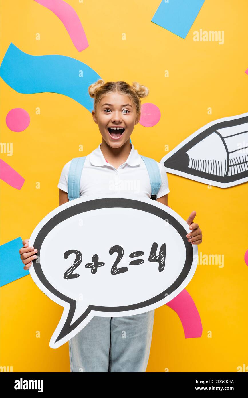 excited schoolchild holding speech bubble with math illustration near ...