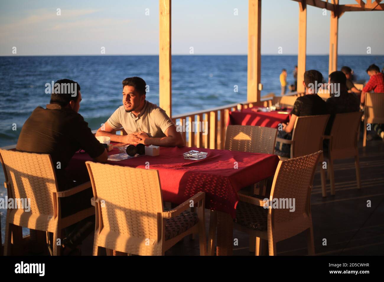 Palestinians enjoy their time at a beach side cafe in Gaza City ...