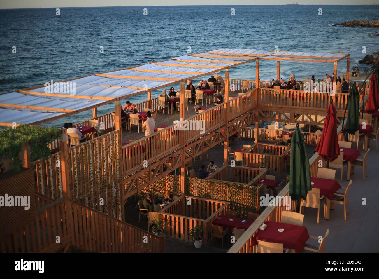 Palestinians enjoy their time at a beach side cafe in Gaza City ...