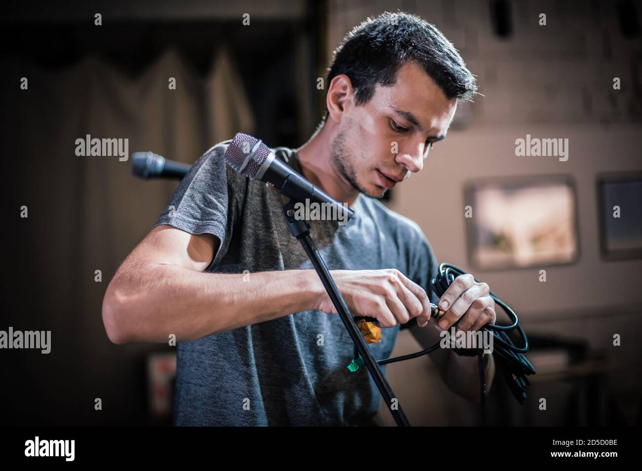 Theater audio technician adjusting an microphones on the scene ...