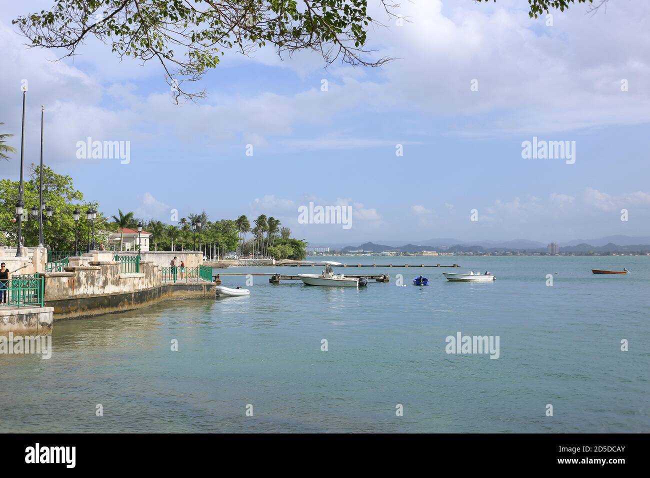 View of a small marina with boat anchored in the harbor and mountains ...