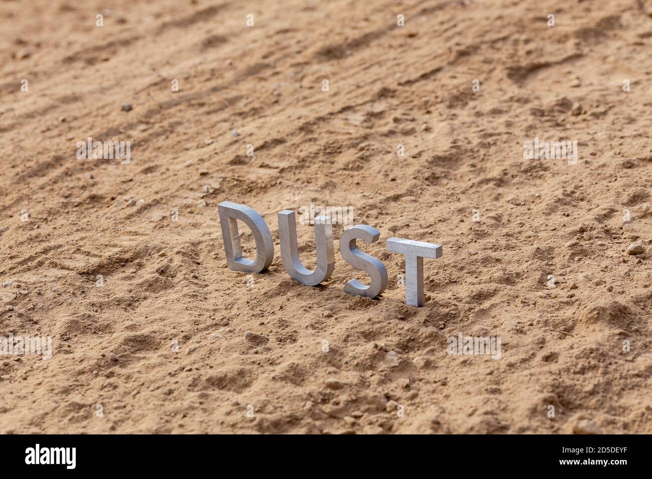 the word dust standing on dusty road surface in linear perspective ...