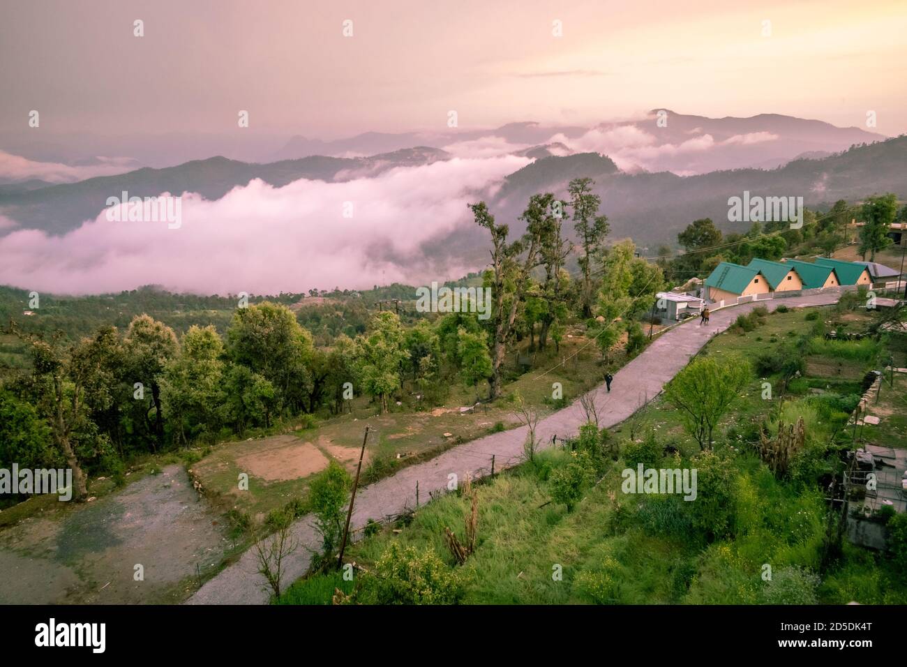 Aerial view of a road leading to a resort with misty HImalayan ...