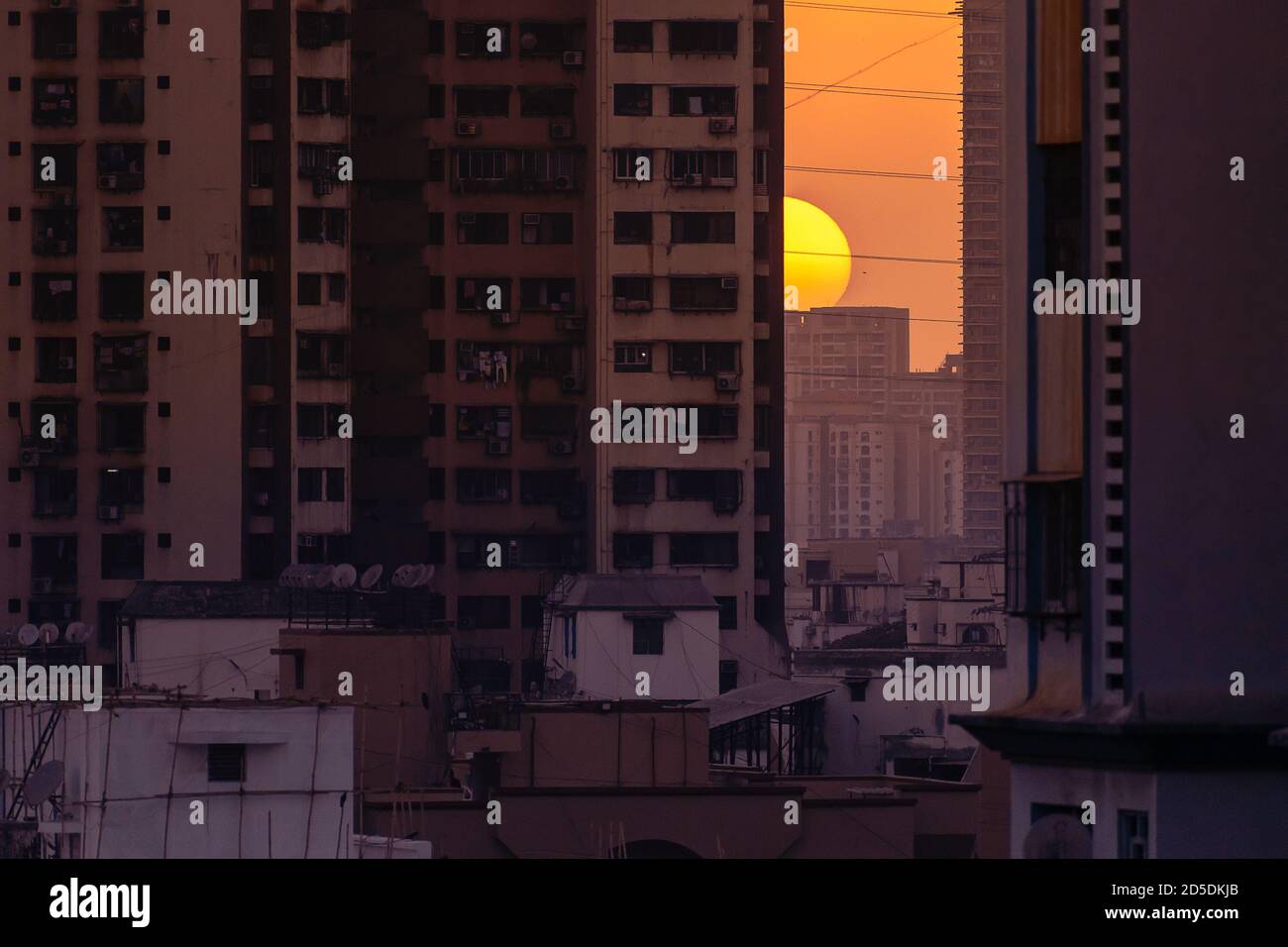 Sun setting behind buildings in Mumbai Stock Photo - Alamy