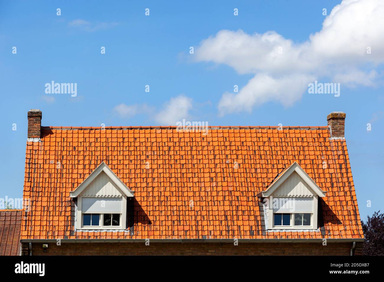 Symmetric red tiled roof with two dormers with rolling shutters and two ...