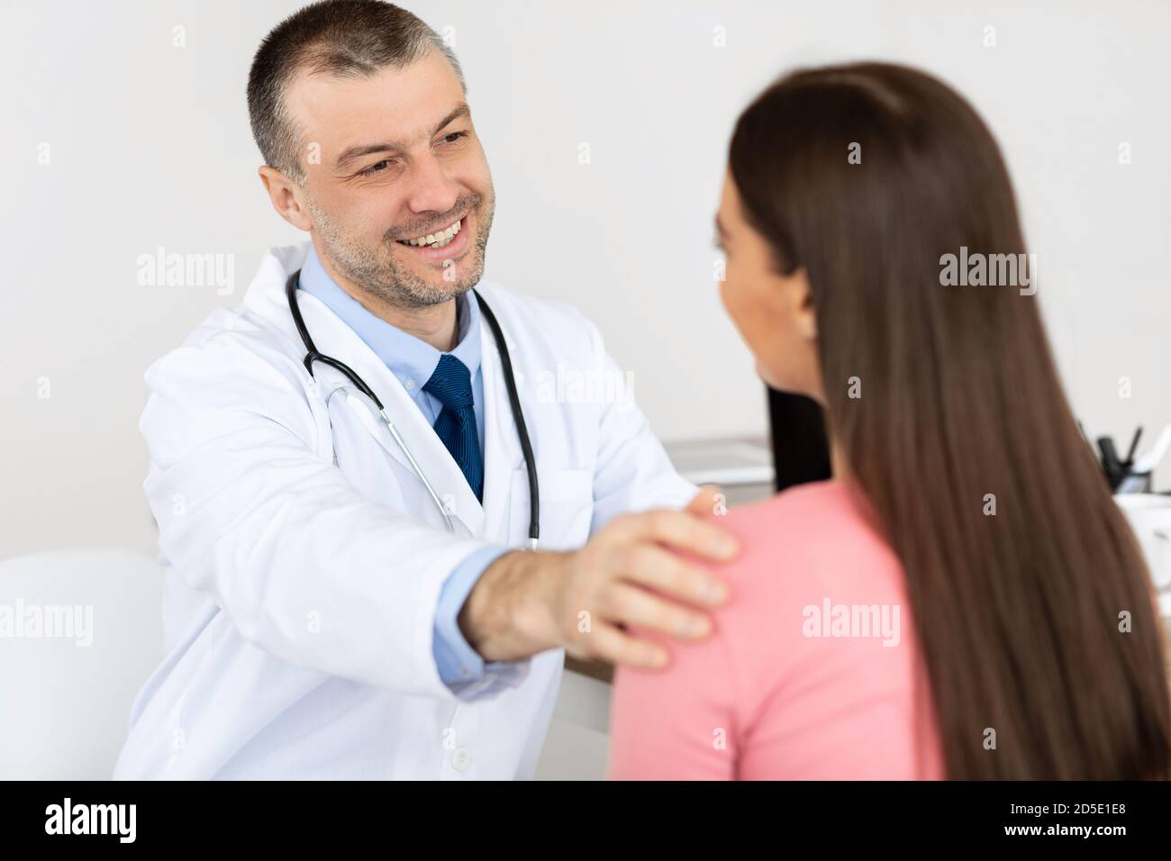 Happy male doctor telling good news to his patient Stock Photo - Alamy