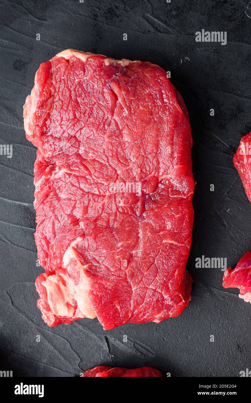 Organic rump beef steaks, top view on black textured table Stock Photo ...