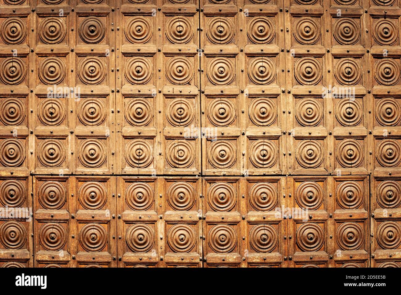 Closeup of an ancient studded wooden door with square and circle shapes ...