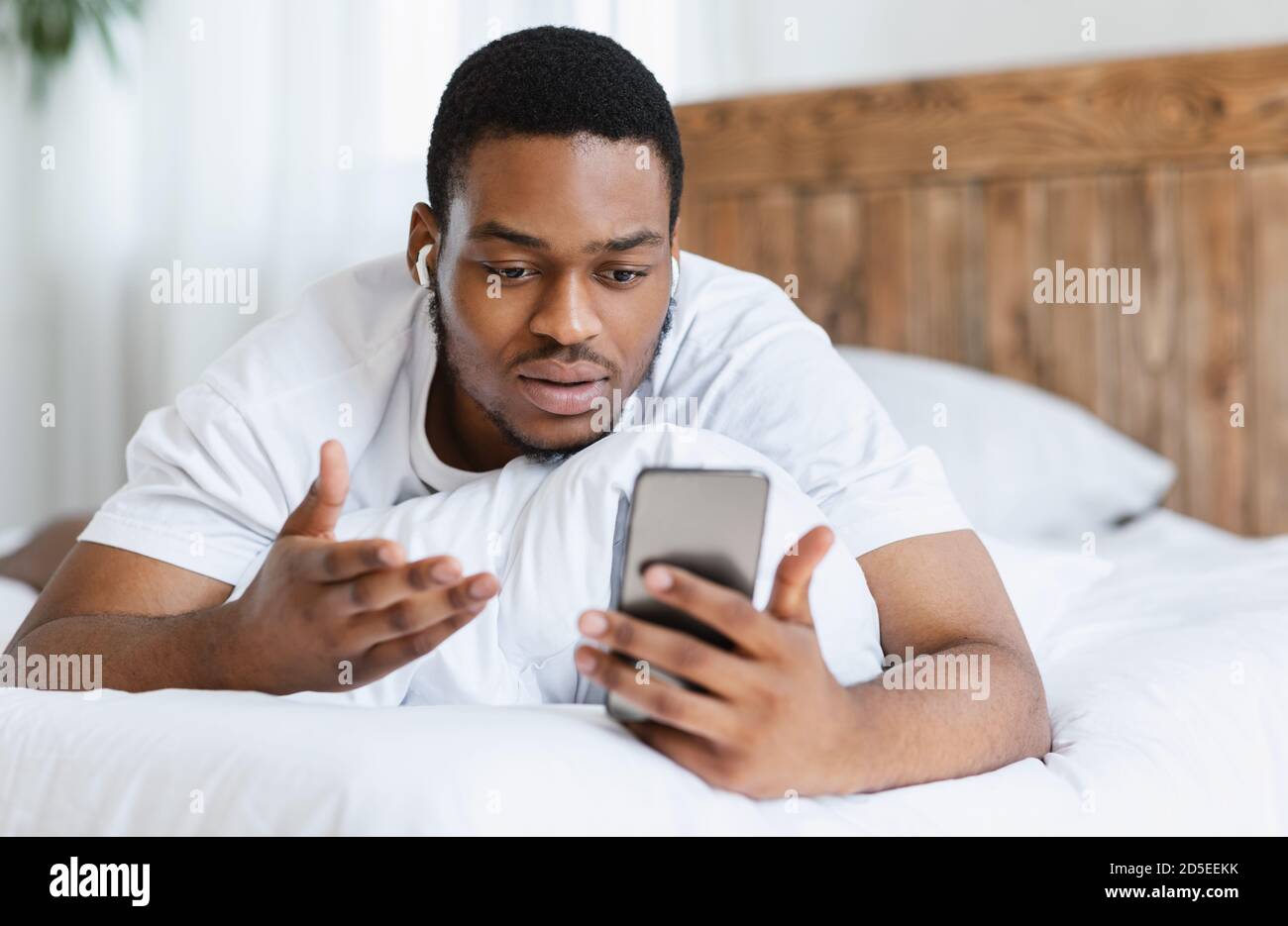 Serious African Man Making Video Call On Smartphone In Bed Stock Photo ...