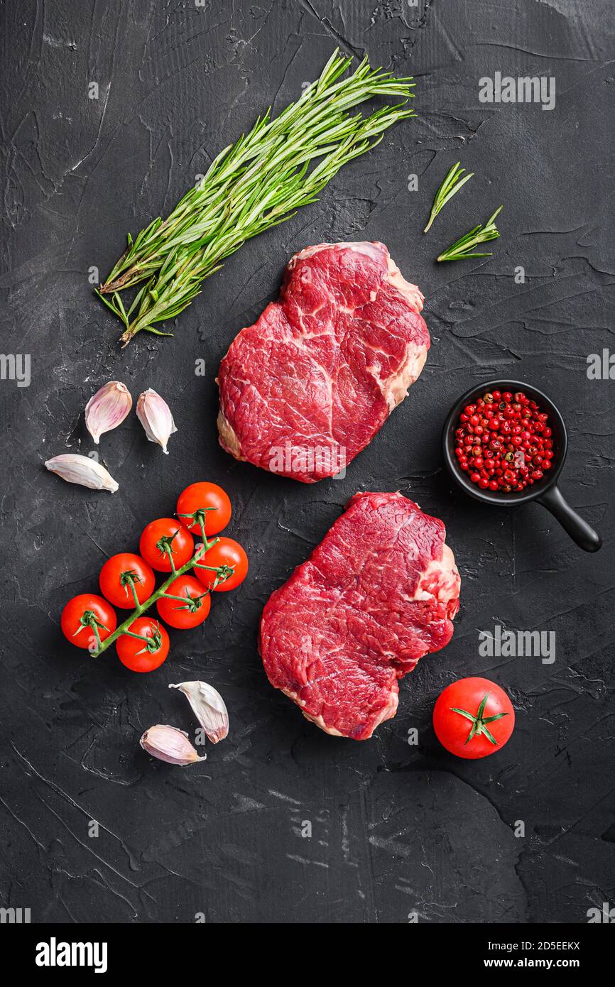 Raw Rump Steaks From Organic Beef Meat Cuts With Rosemary Garlic And Spices Over Black Textured