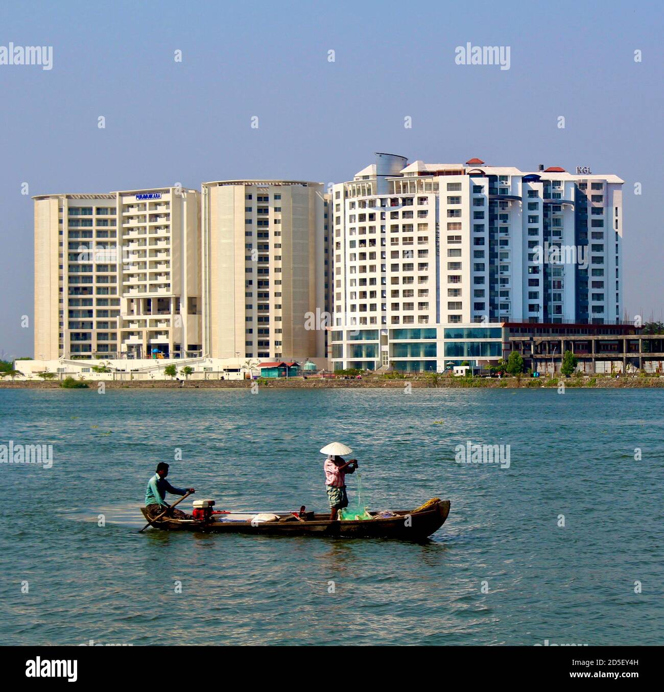 Traditional fisherman in Cochin harbour with modern buildings in ...