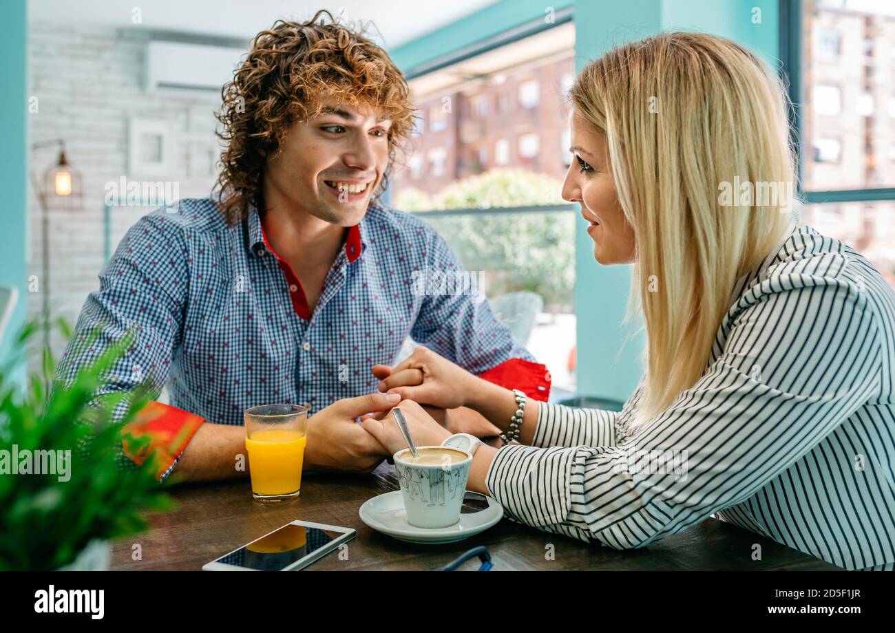 Couple holding hands at a cafe Stock Photo - Alamy