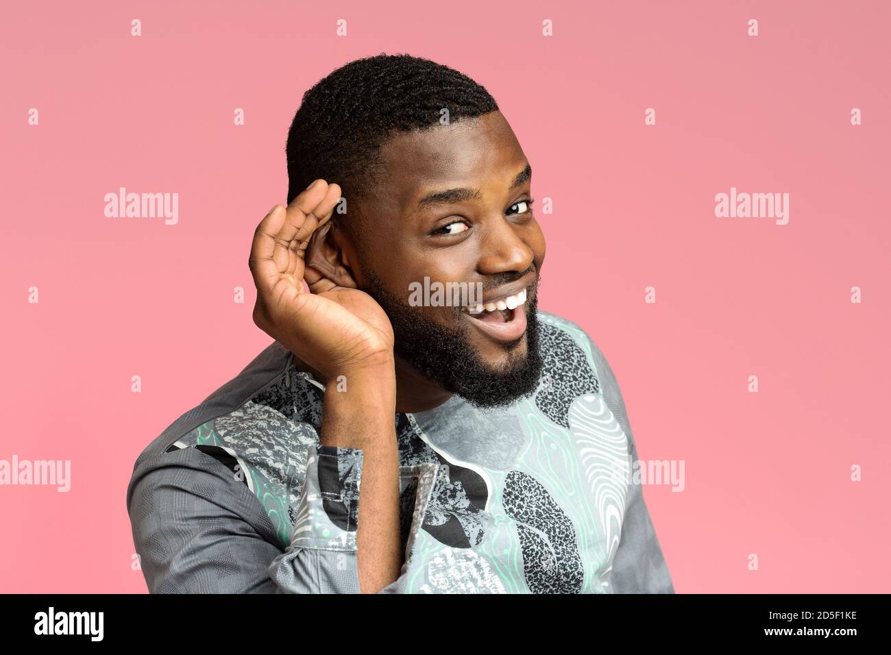Curious african-american man holding hand near ear Stock Photo - Alamy