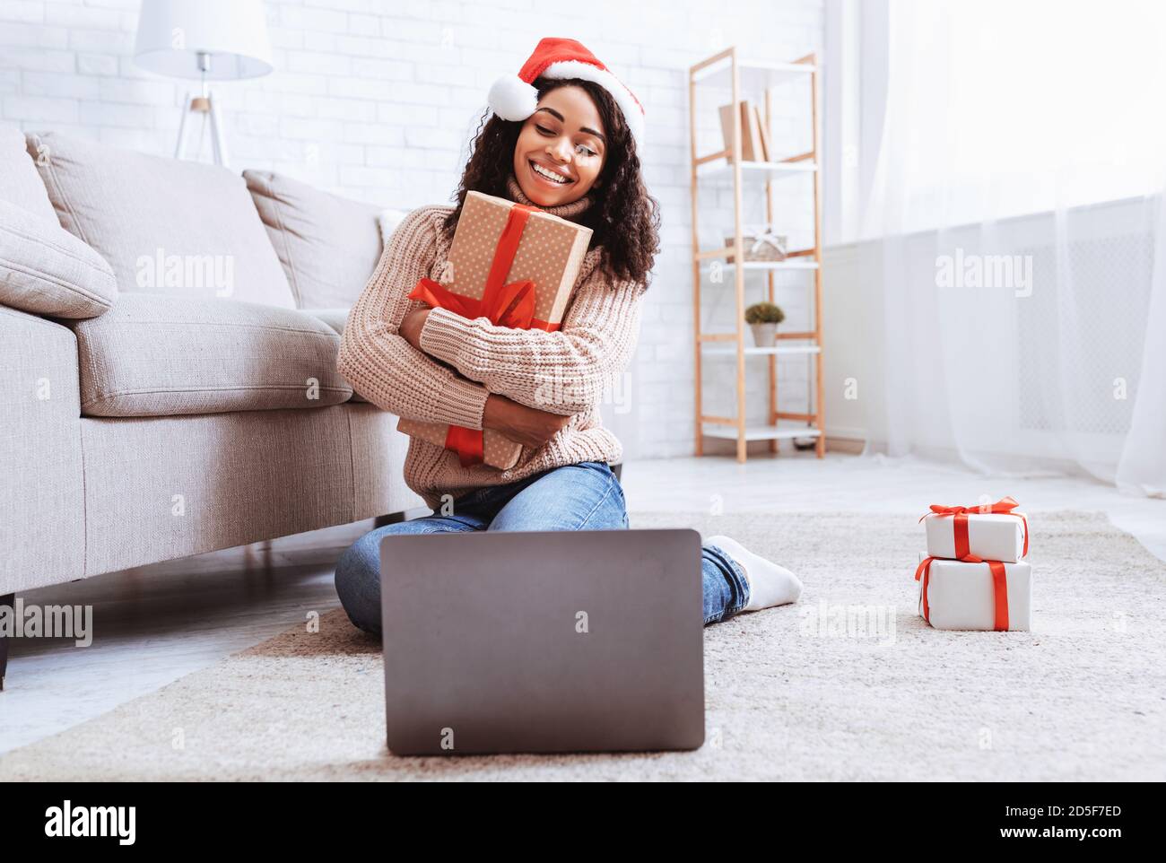 African American Woman Hugging Present Box Using Laptop Stock Photo - Alamy