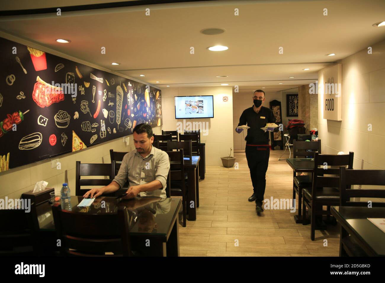 A Palestinian while enjoy their time at a restaurants, in Gaza City ...