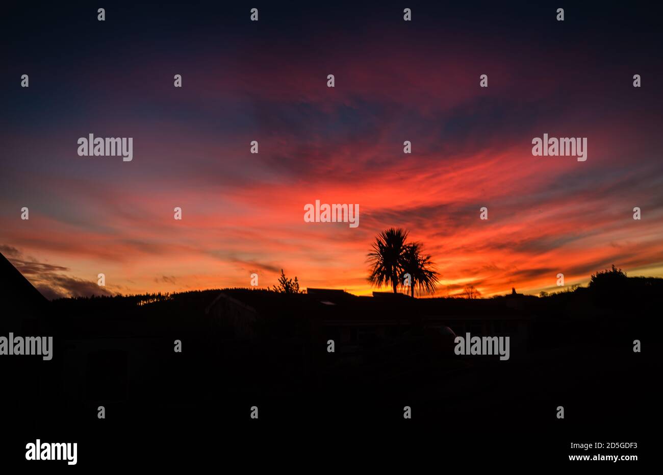 A winter red sky as the sun sets over Budleigh village in Devon Stock ...