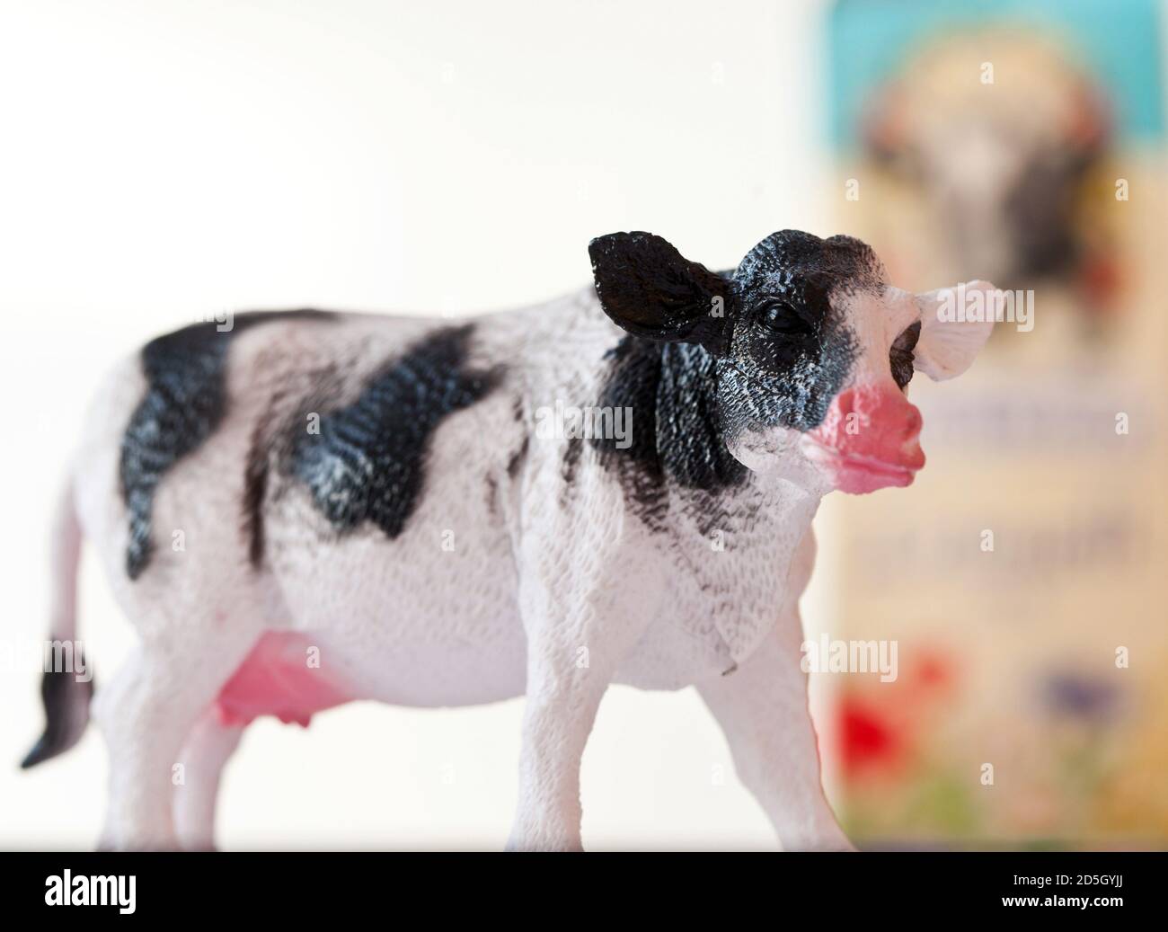 Miniature plastic cow with milk shot on white background Stock Photo ...