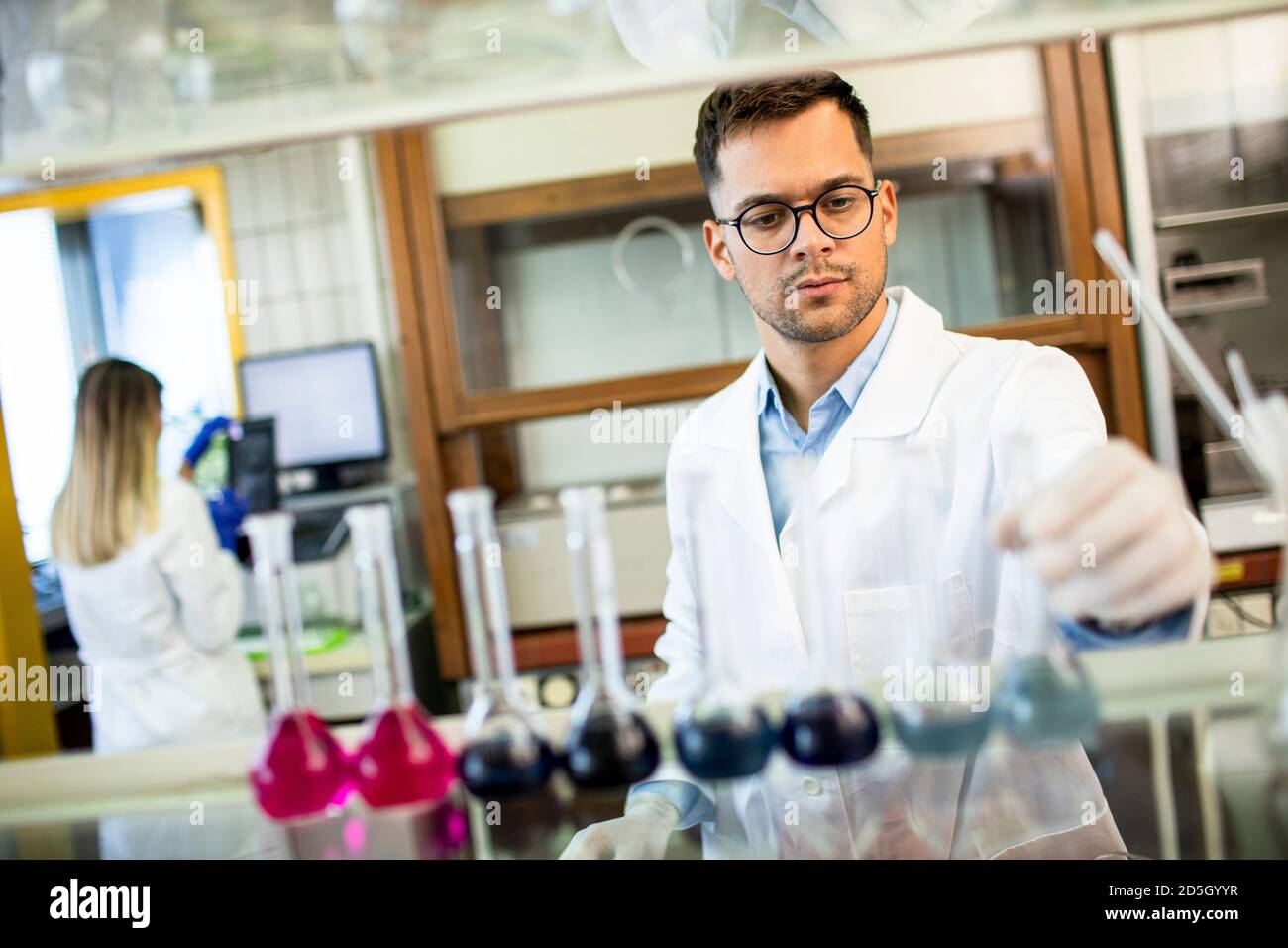 Young researcher checking test tubes in the laboratory Stock Photo - Alamy