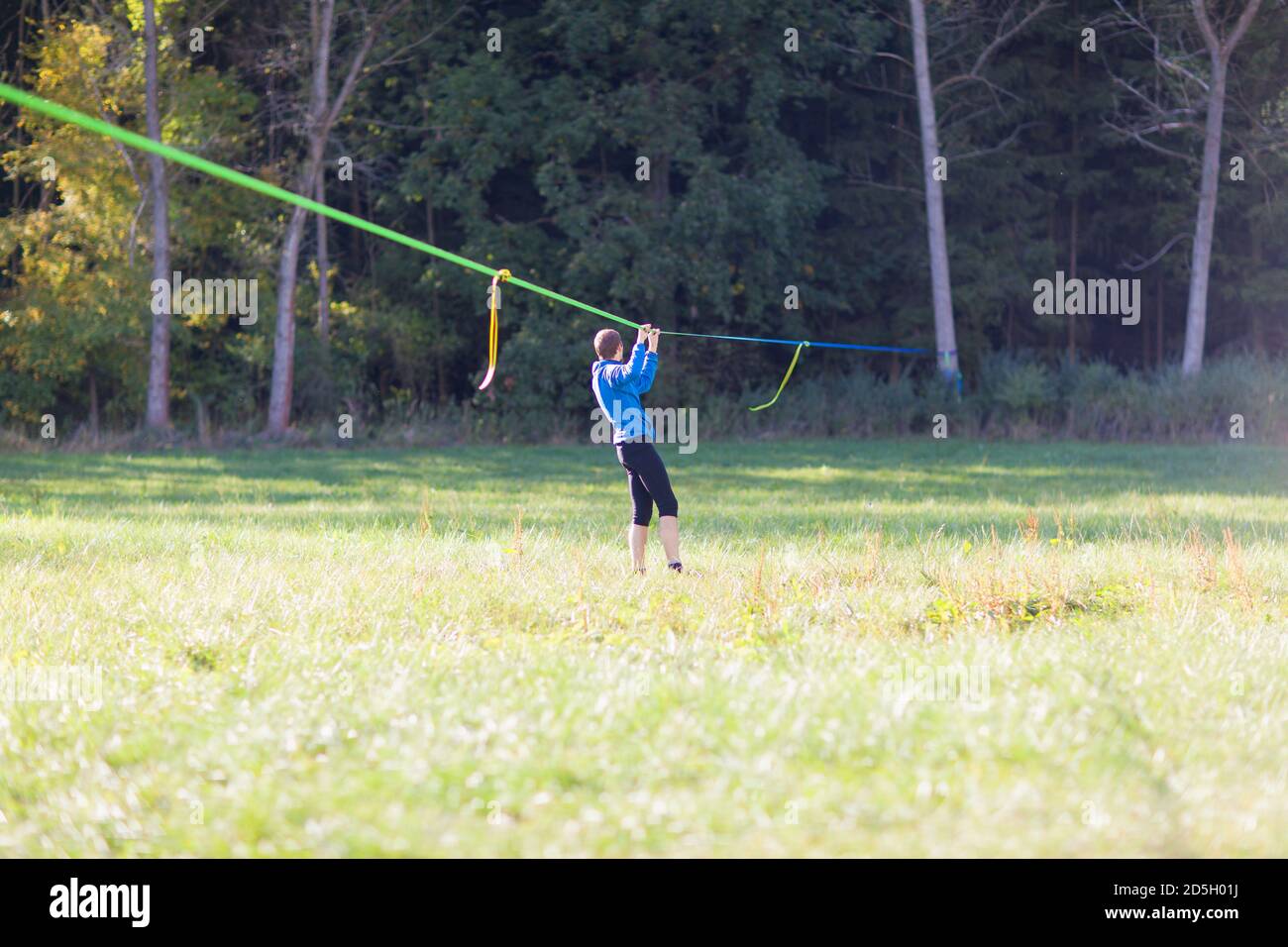 Man walking, jumping and balancing on rope in park Sports a tightrope ...