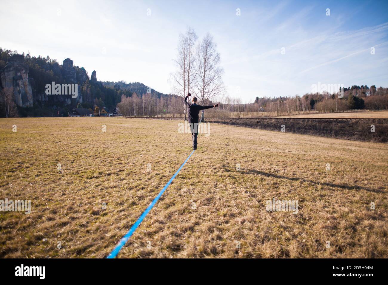 Man walking, jumping and balancing on rope in park Sports a tightrope ...