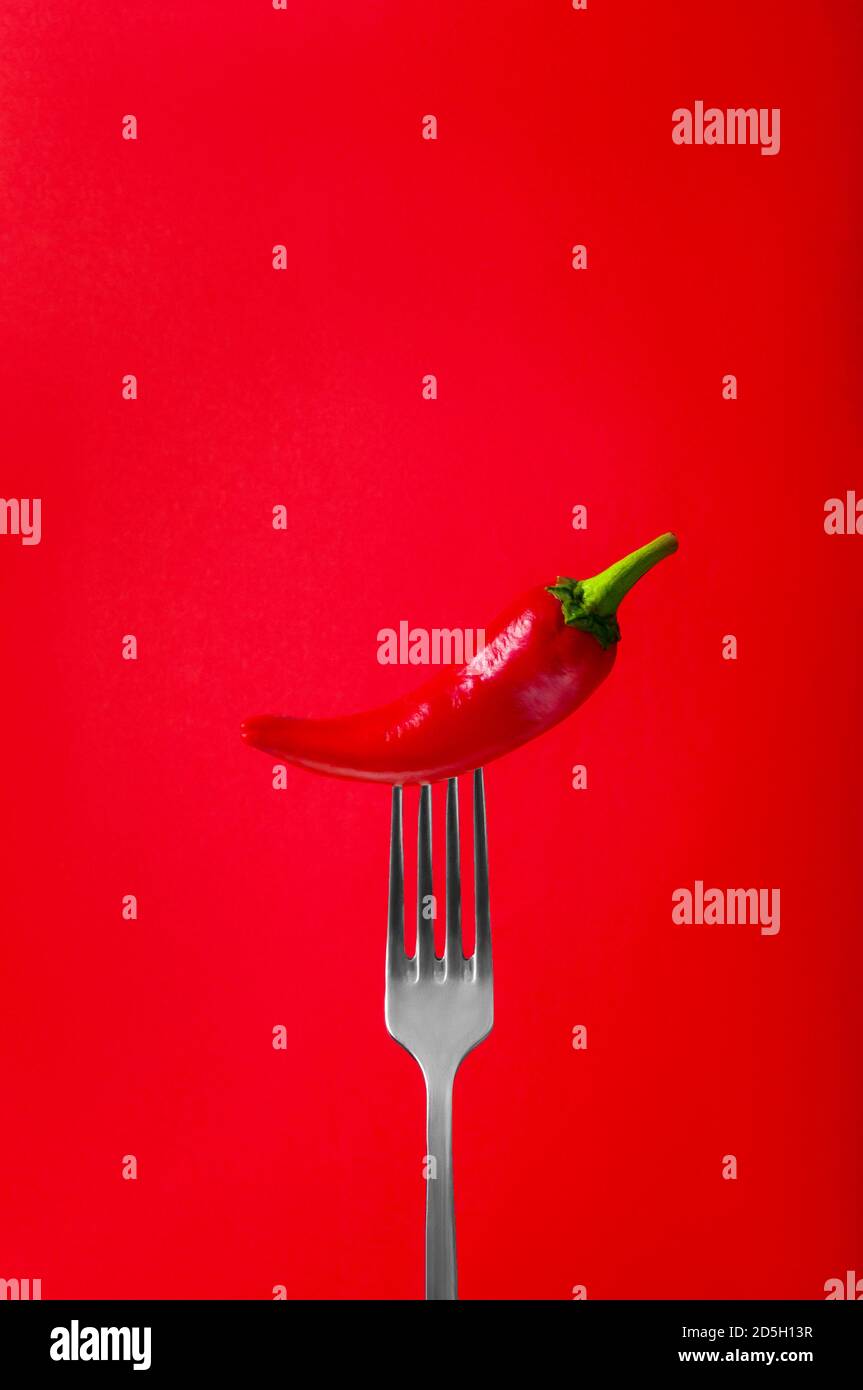 Red Hot Chili Pepper on Fork with Smoke on Red Background Stock Photo ...