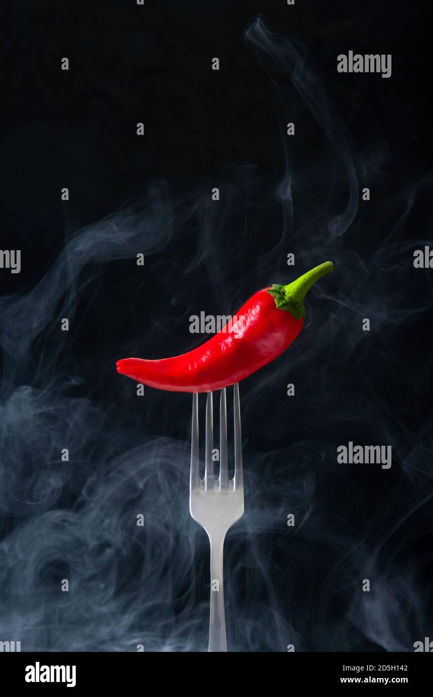 Red Hot Chili Pepper on Fork with Smoke on Black Background Stock Photo ...