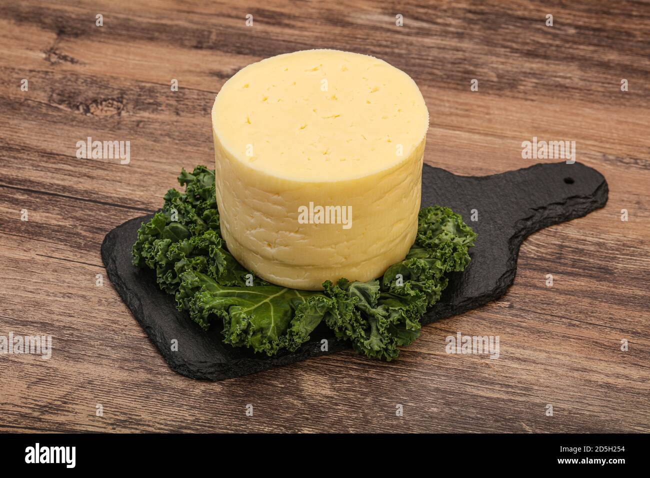 Yellow round dairy soft cheese piece Stock Photo - Alamy