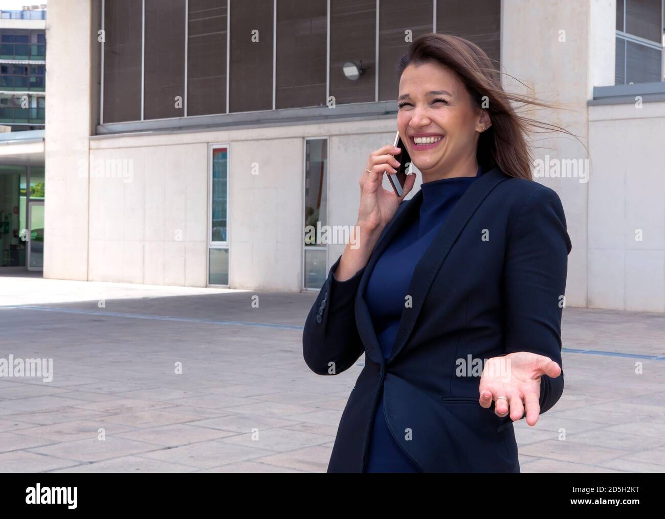 Gorgeous female executive talking on the phone in friendly conversation ...