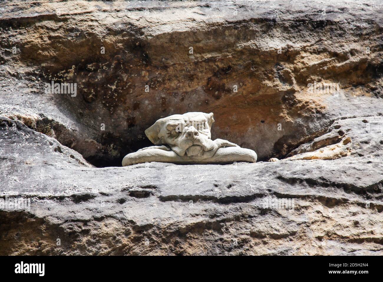Rocky gap with stone monster looking out Stock Photo - Alamy