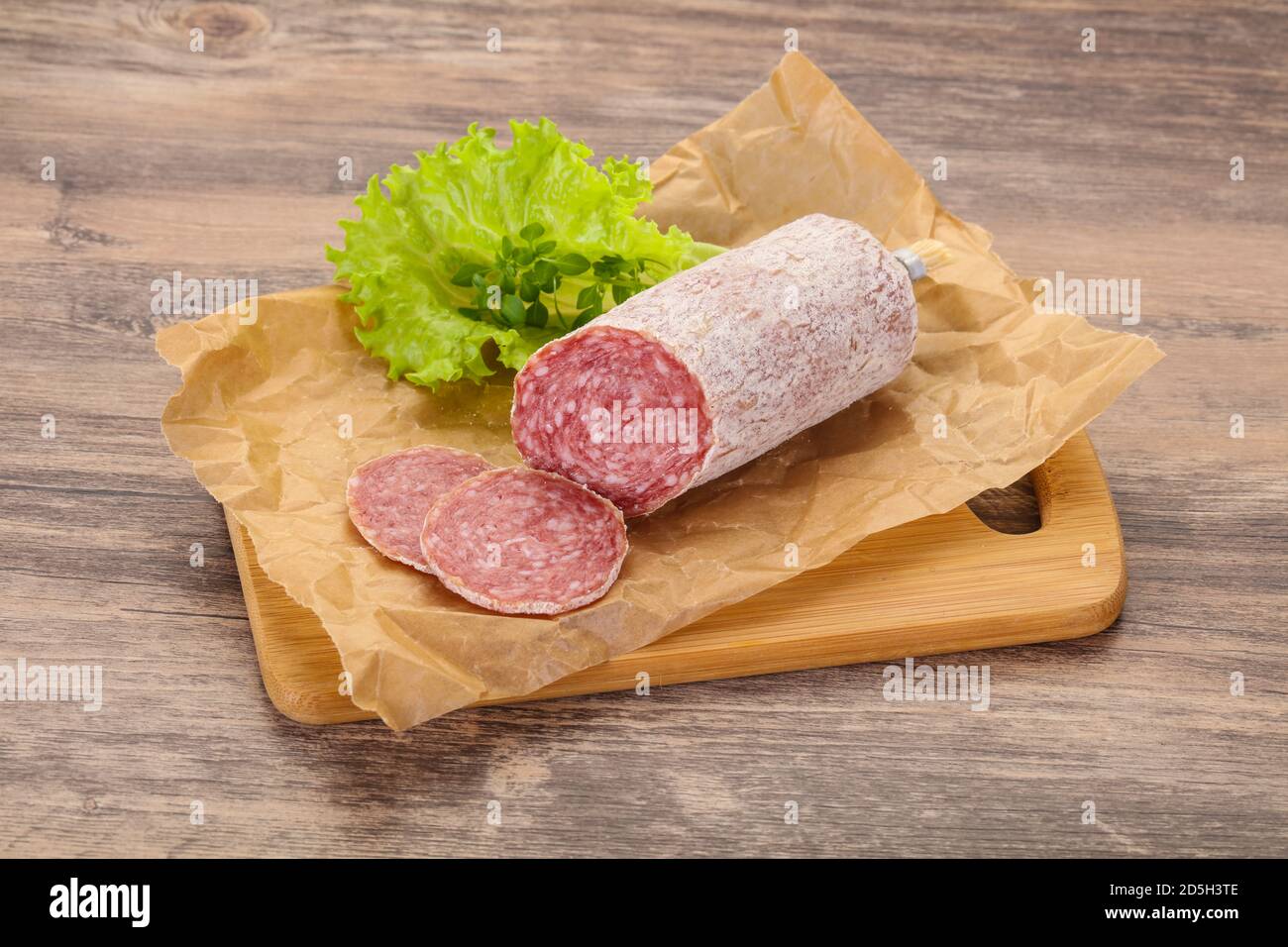 Italian dry Saliami pork sausage served salad leaves Stock Photo - Alamy