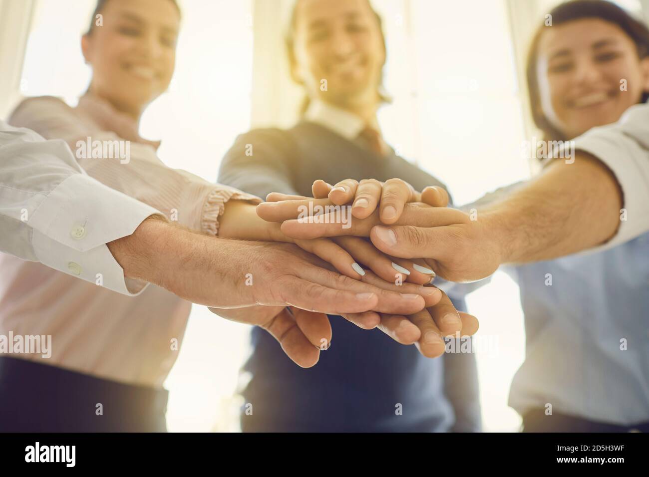 Close-up of smiling business people hands pyramid expressing successful ...
