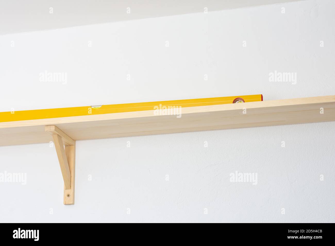The process of fixing the wooden shelf to the wall, the level tool ...