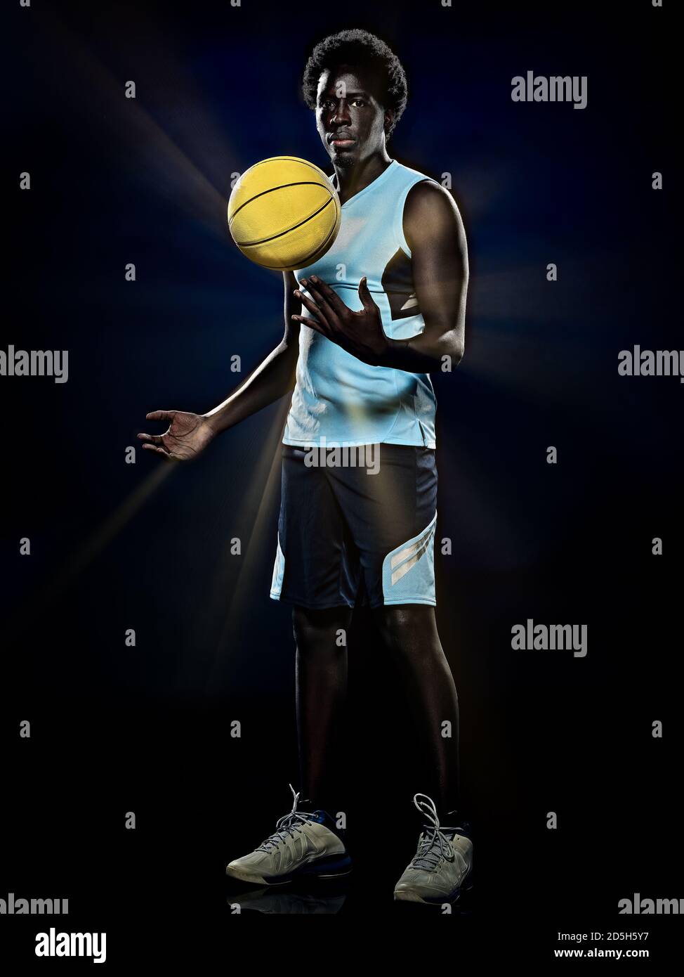 one young african basketball player man in studio isolated on black ...