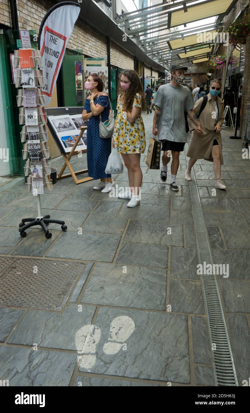 Visitors to the famous Camden Lock market in London, with signs ...