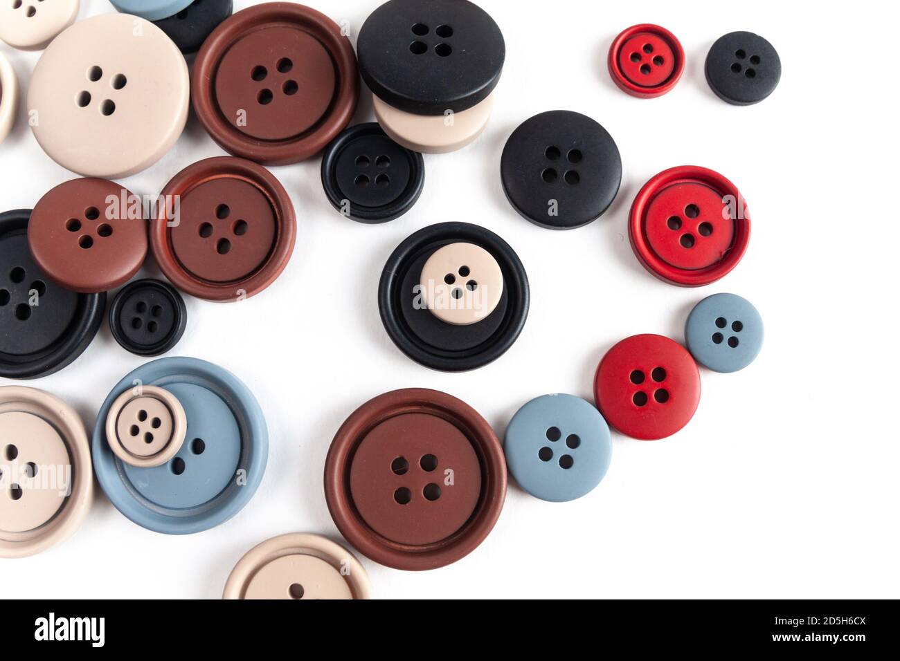 Pile of color brown, beige, grey, red, black plastic matte buttons on ...