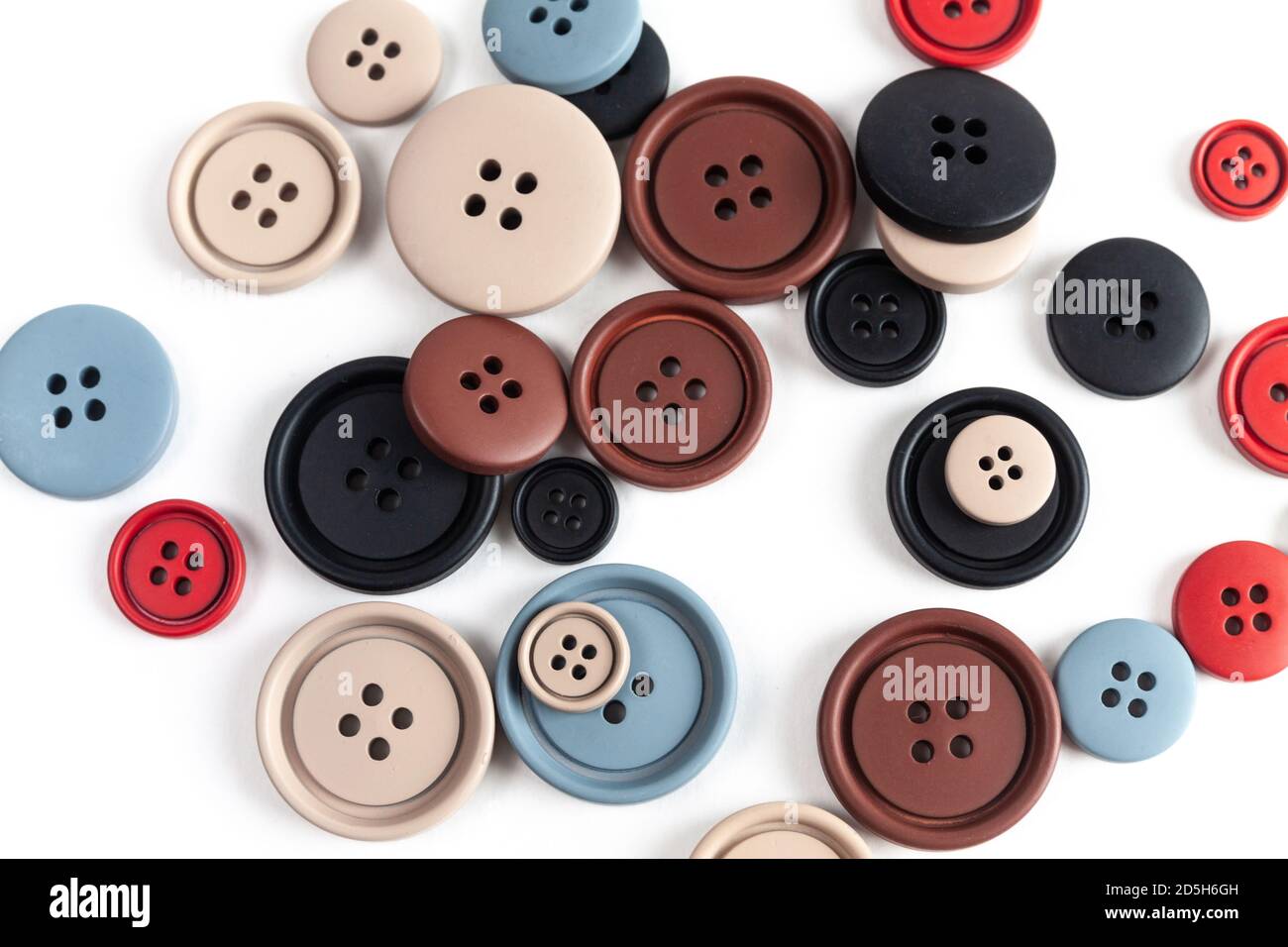 Pile of color brown, beige, grey, red, black plastic matte buttons on ...