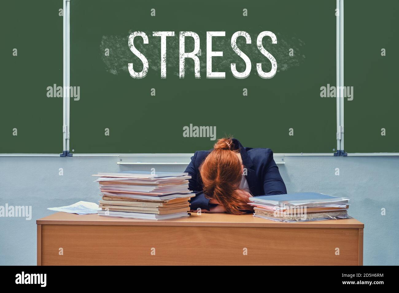 Sad teacher at the school desk at the blackboard with the text "Stress ...